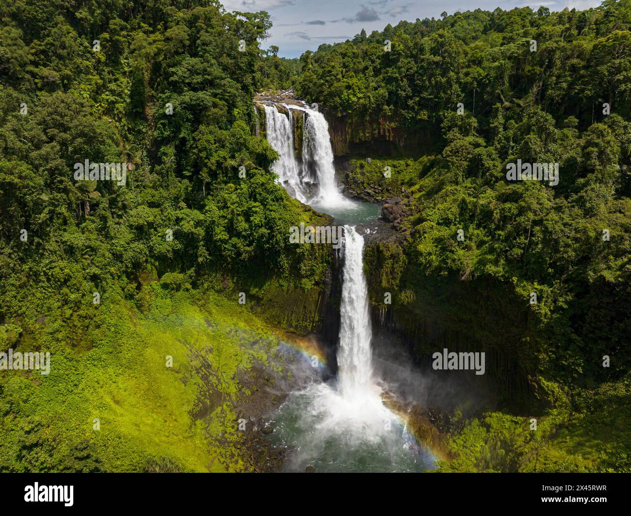 Tropical waterfall in a mountain canyon surrounded by jungle ...