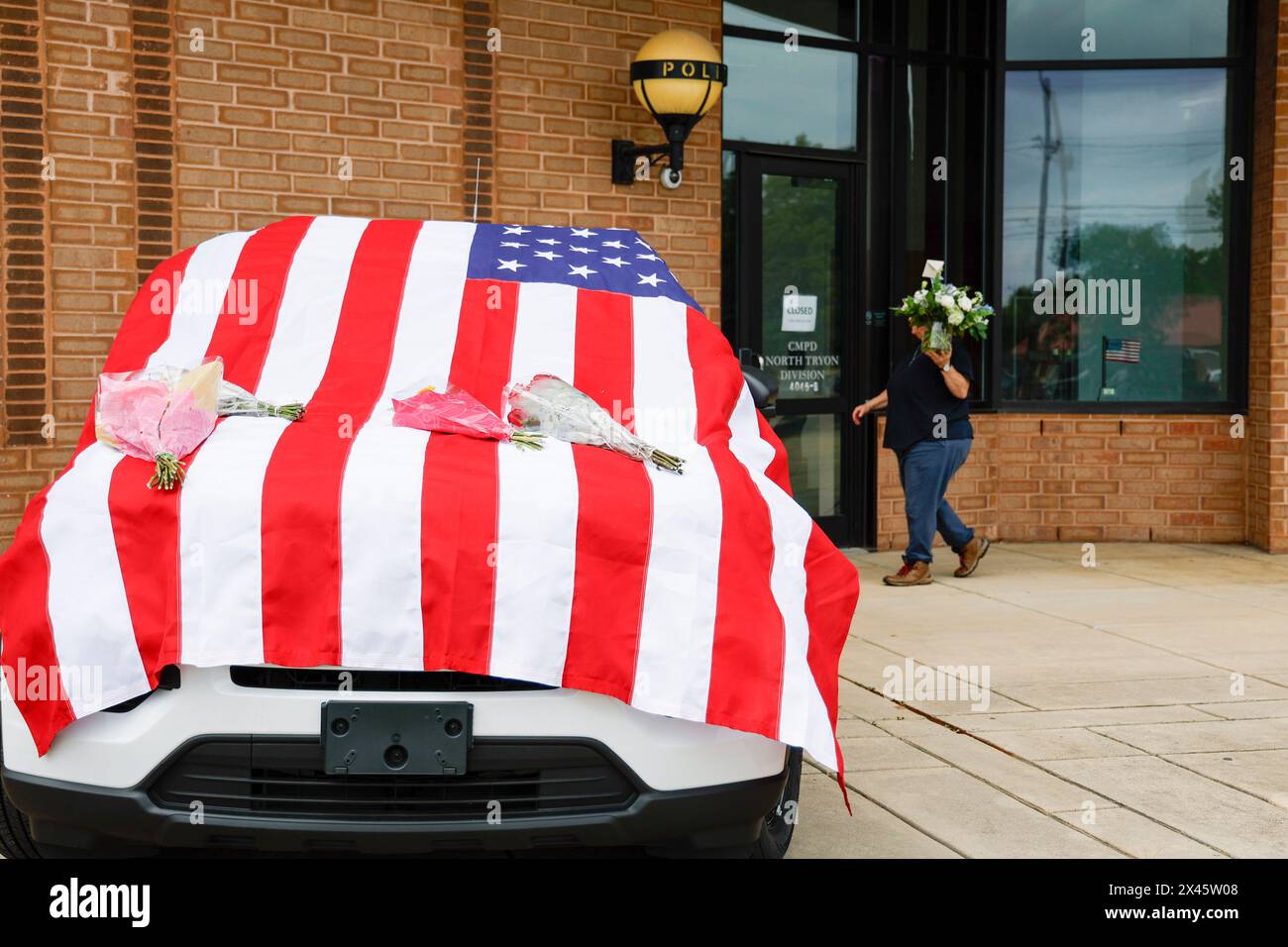 Flowers are delivered as an American flag and flowers cover a Charlotte-Mecklenburg police ...
