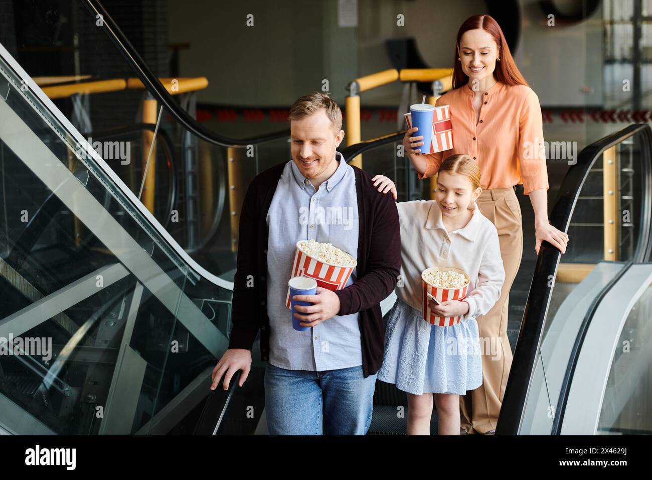 A man and two little girls happily walk down an escalator together in a ...