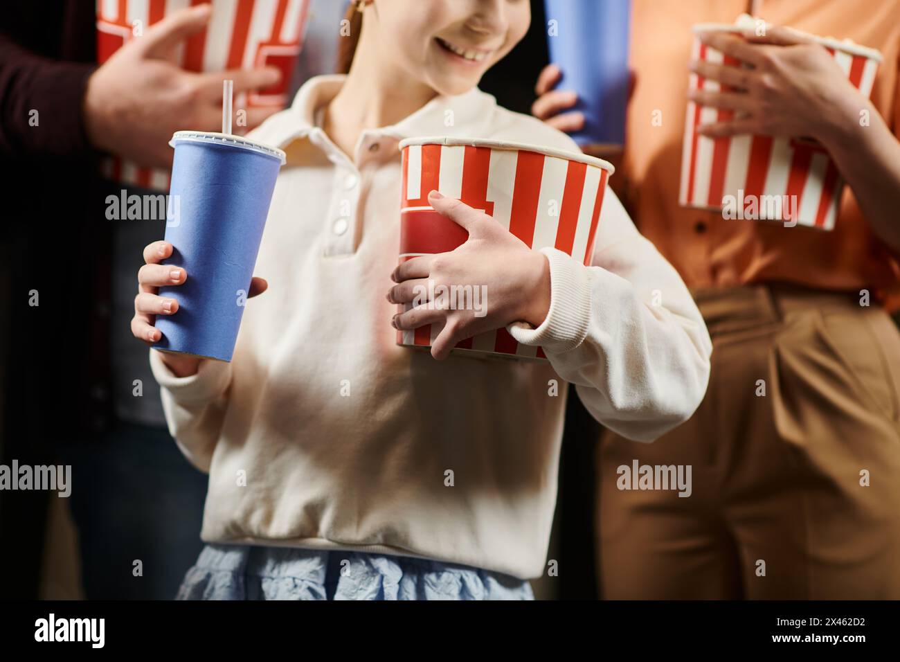 A happy family stands together in a circle, holding cups and enjoying ...