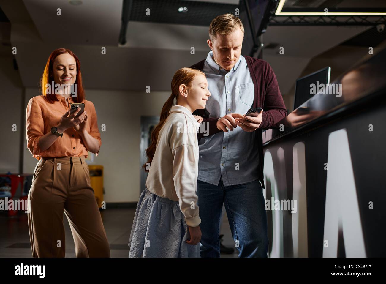 A group of people, including a happy family, stand closely in a cinema ...