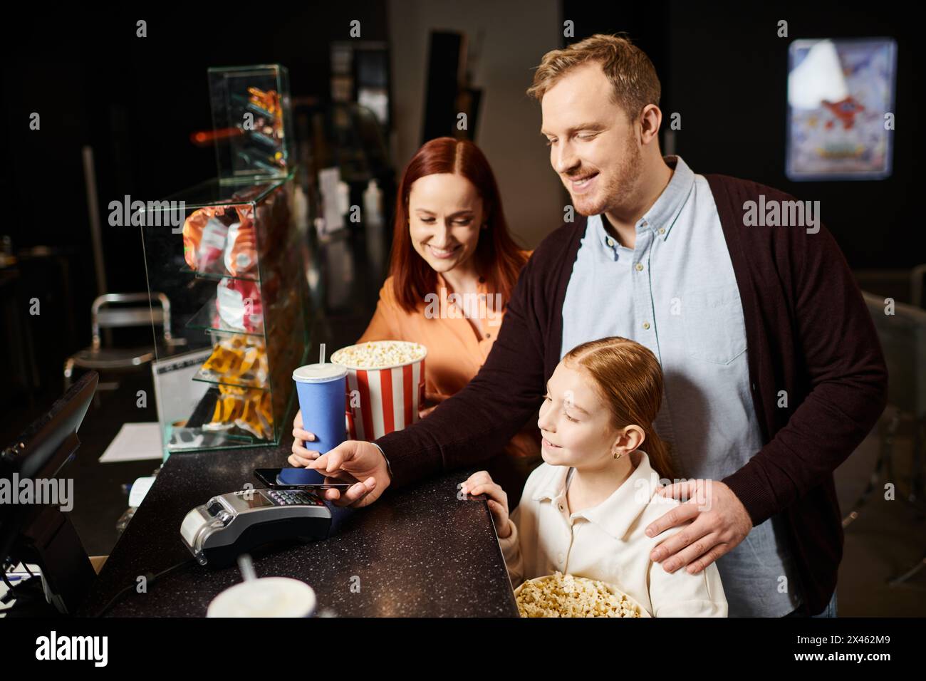 A father and his daughter happily enjoy popcorn at a table during a fun ...