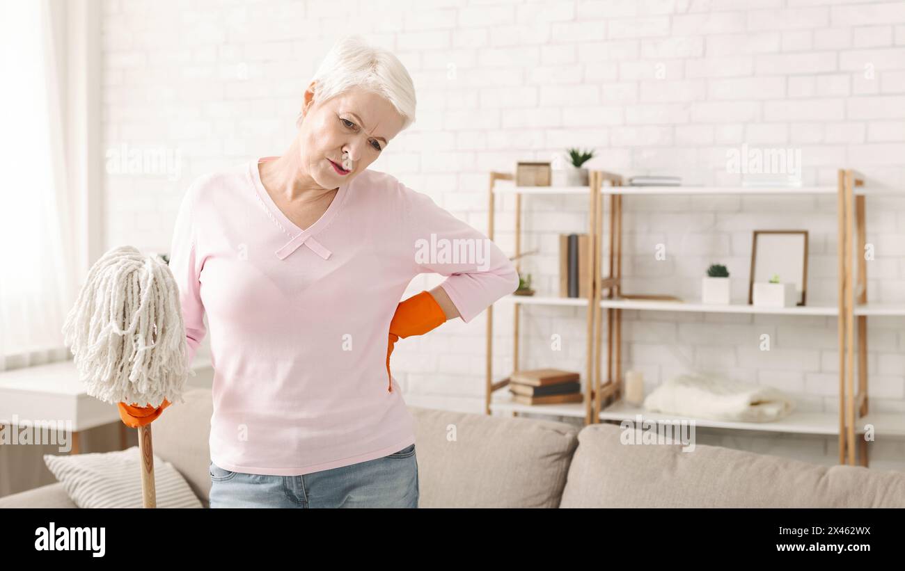 Woman Cleaning Living Room With Mop, Touching Back Stock Photo - Alamy