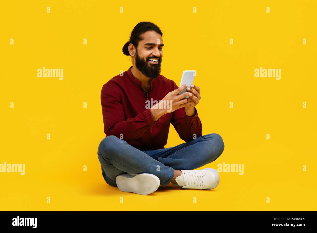 Indian Man Sitting on Floor Using Cell Phone Stock Photo - Alamy