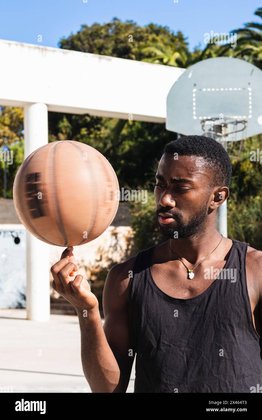 Determined African American male basketball player spinning and ...