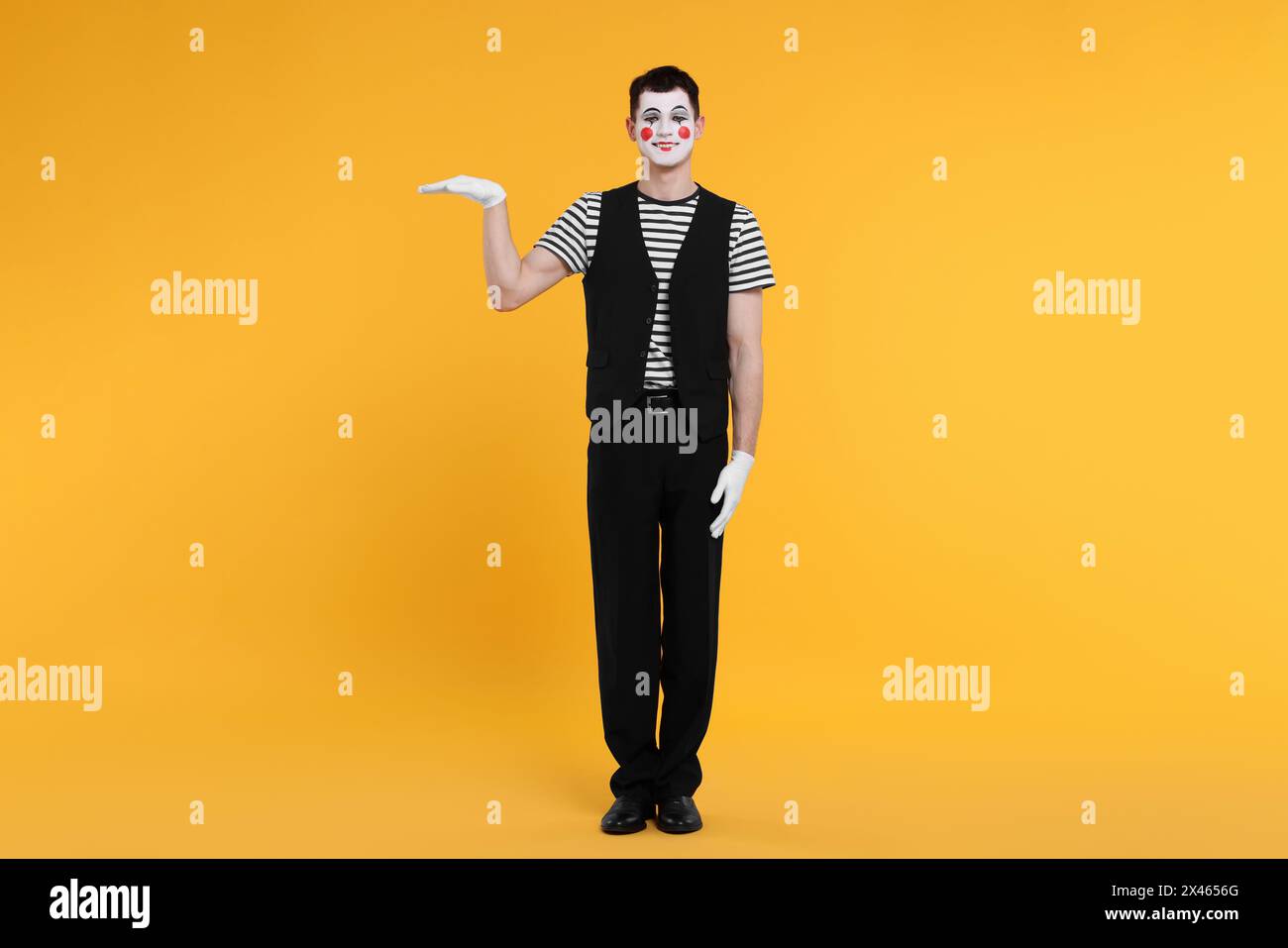 Funny mime artist posing on orange background Stock Photo - Alamy
