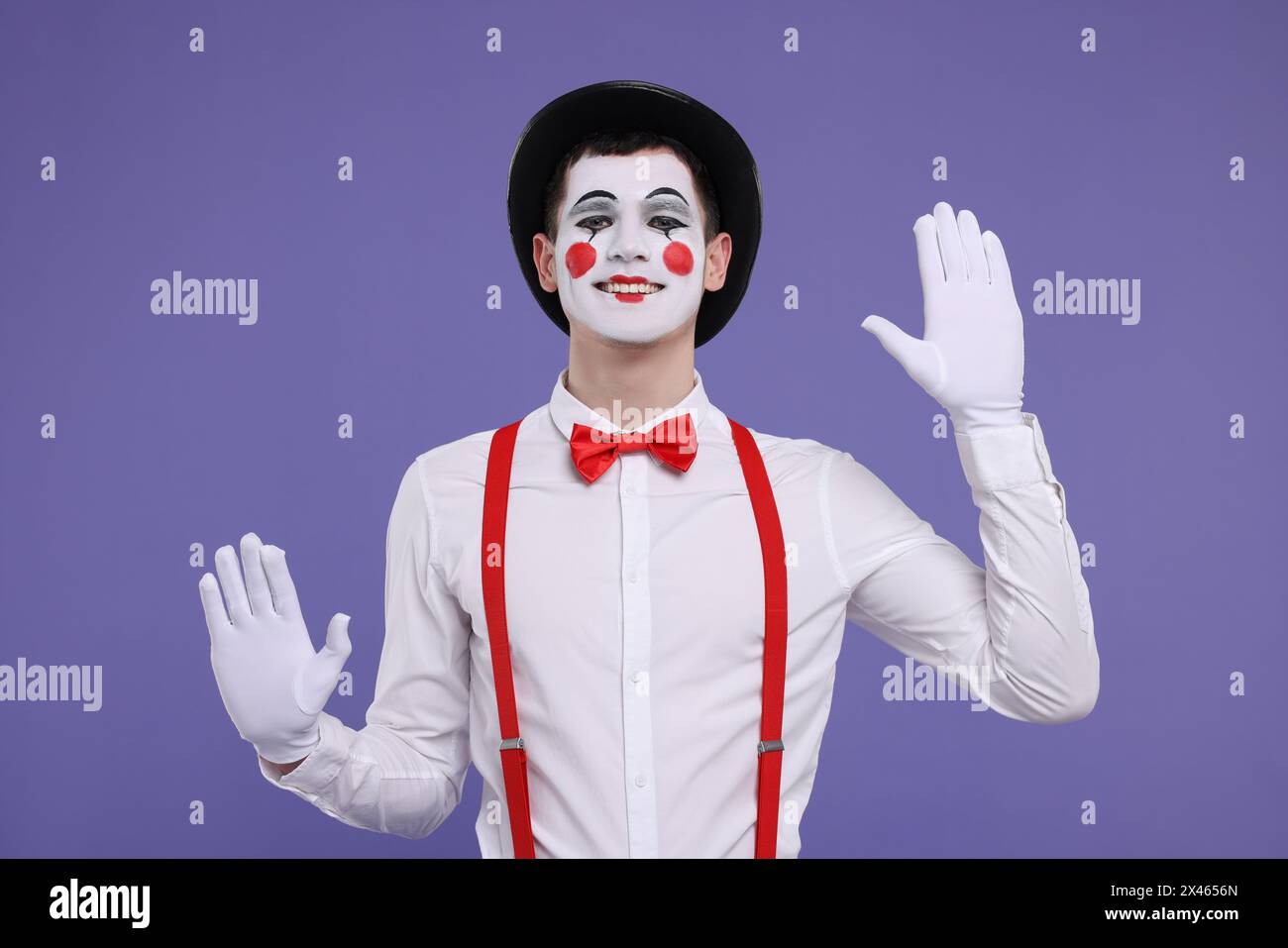 Funny mime artist in hat posing on purple background Stock Photo - Alamy