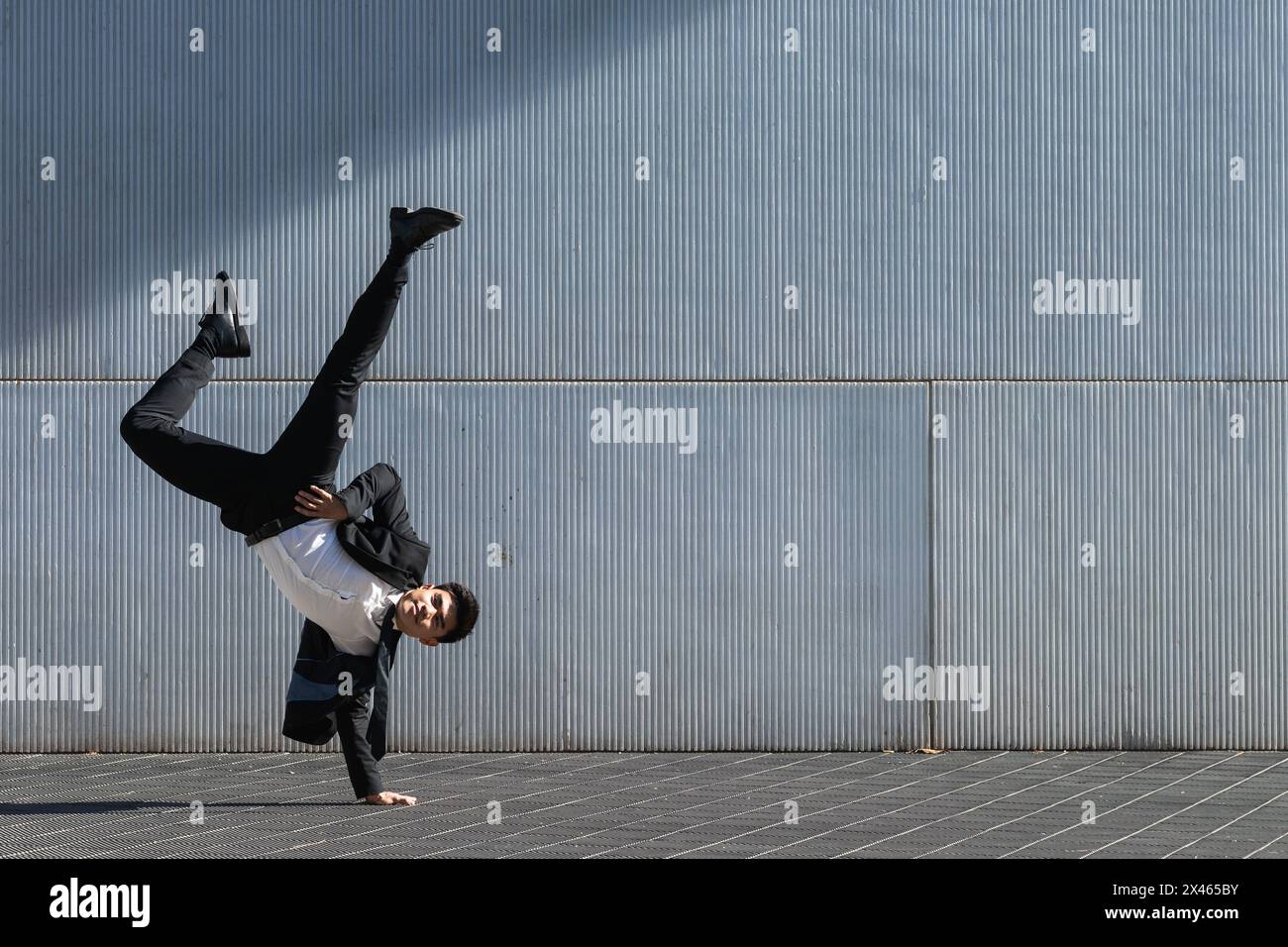 Asian male entrepreneur in formal suit showing breakdance movement and ...
