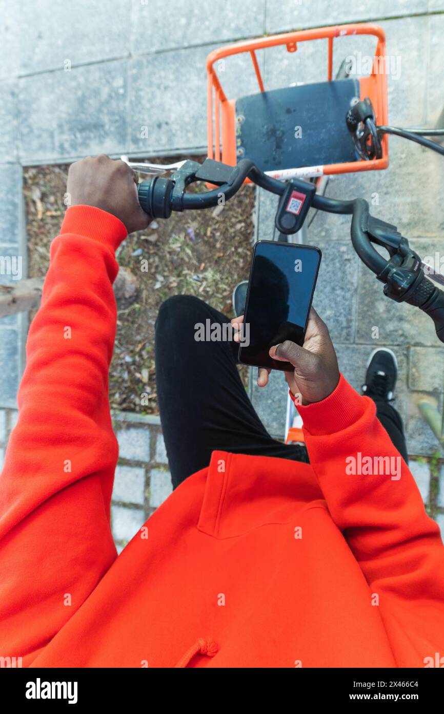 From above of crop faceless young black guy in trendy outfit using ...