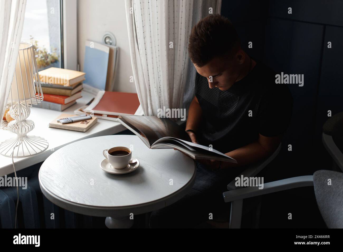 Beautiful Modern Man Rest In A Restaurant, Reading A Book And Drinking ...