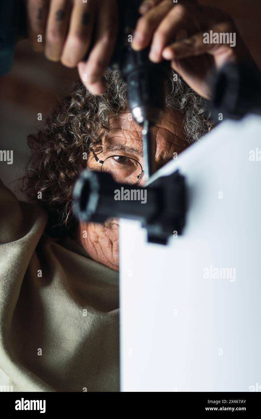 Concentrated unrecognizable senior male furniture maker with curly hair ...