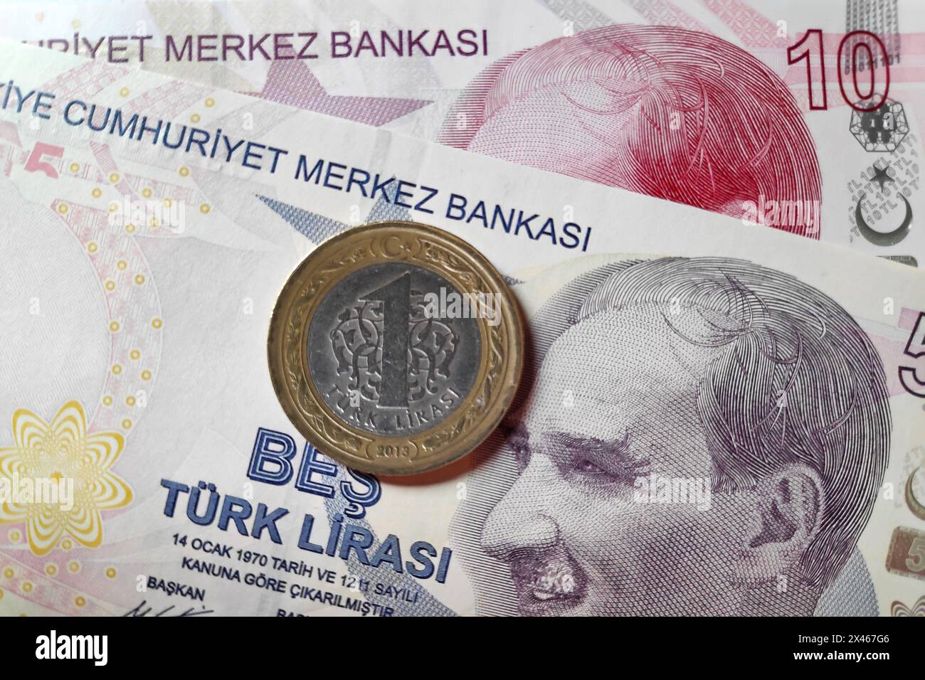 Close-up on a coin on top of a banknote of 5 an 10 Turkish lira (TRY ...