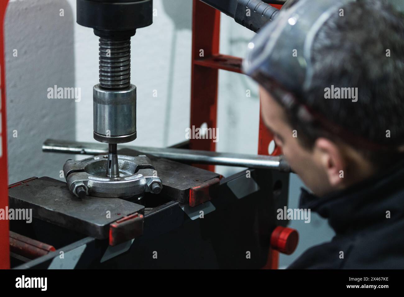 Side view of attentive adult male auto mechanic in protective goggles ...