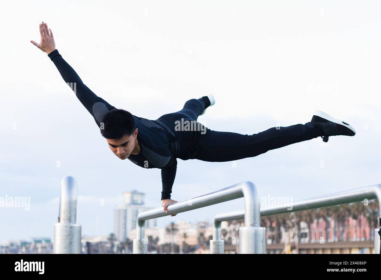 Low angle full body of confident young Asian male gymnast performing ...