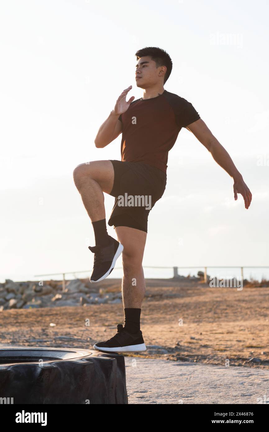 Full body side view of determined young Asian male in sportswear ...