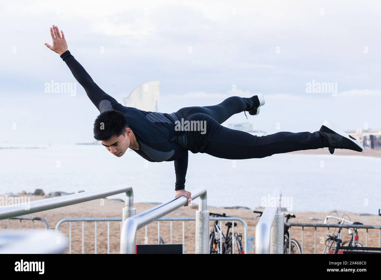 Low angle full body of confident young Asian male gymnast performing ...