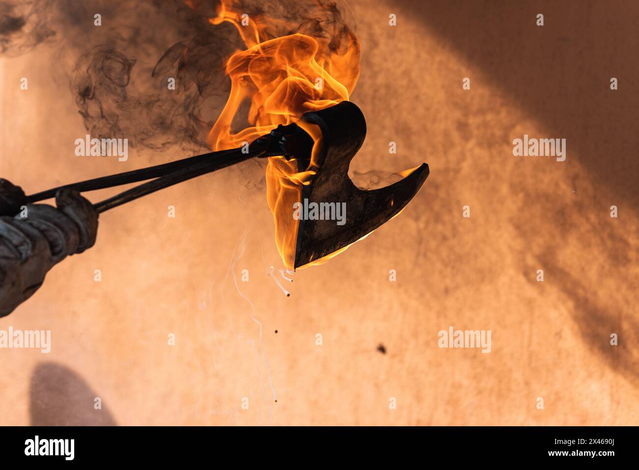 Faceless artisan hardening burning iron sharp weapon in hot water ...