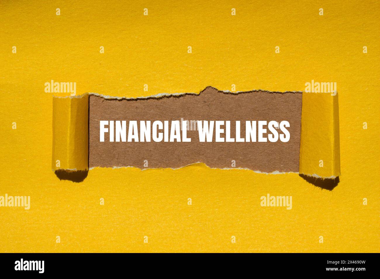 Financial wellness words written on ripped yellow paper with brown ...