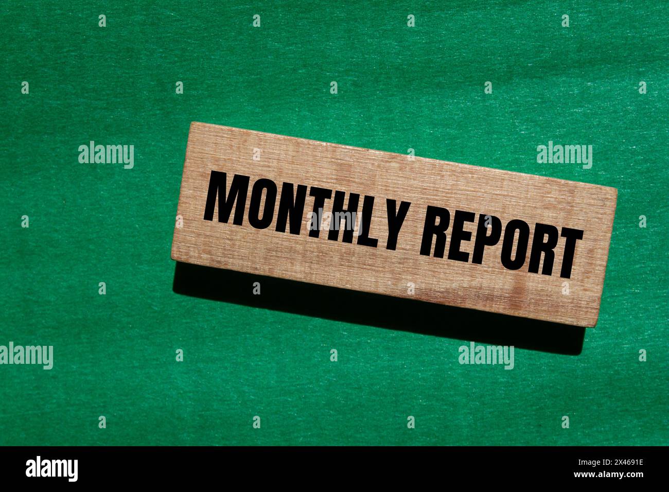 Monthly report words written on wooden blocks with green background ...
