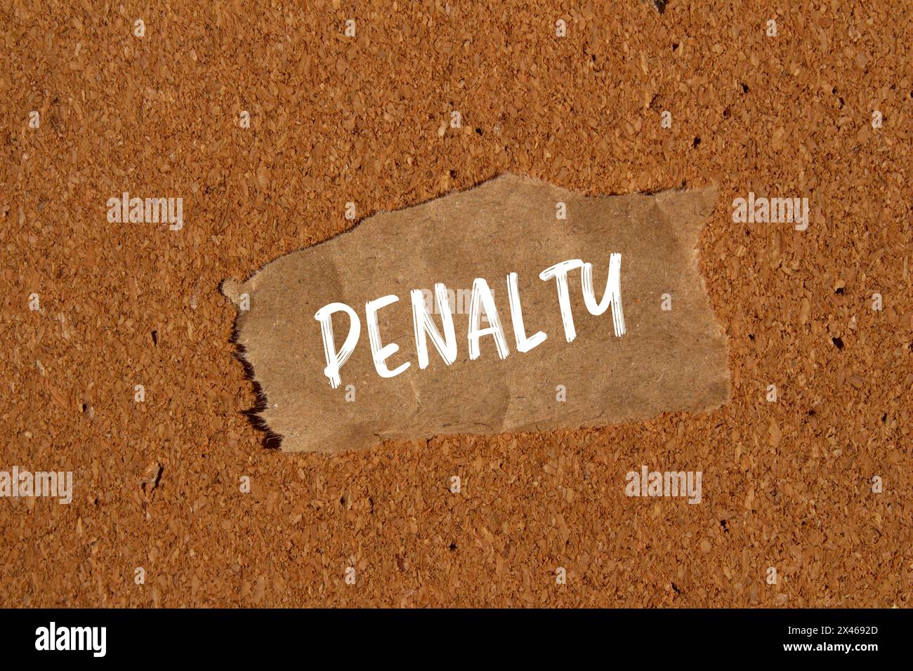Penalty word written on ripped brown paper piece with brown background ...