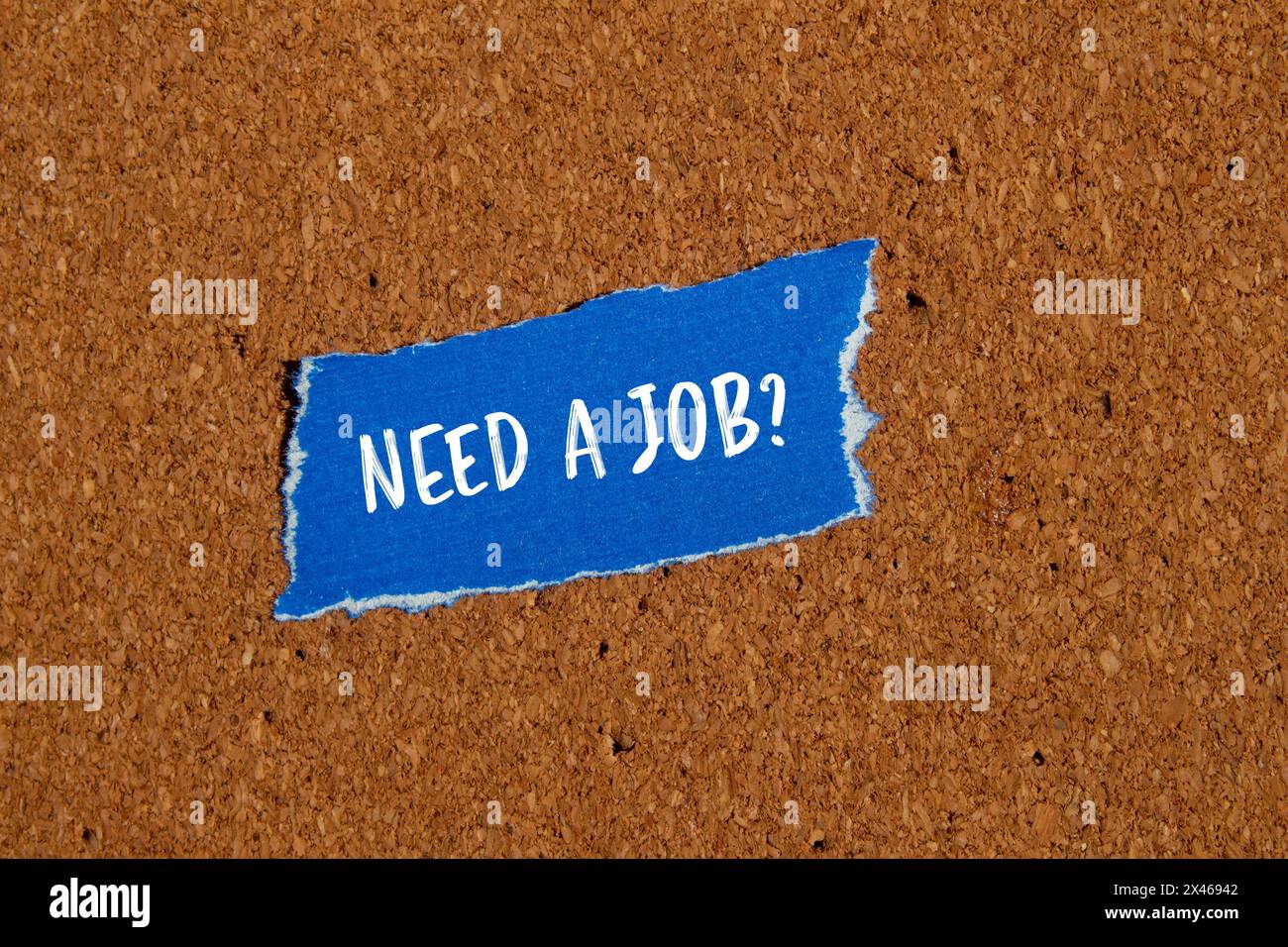 Need a job ? written on ripped blue paper piece with brown background ...