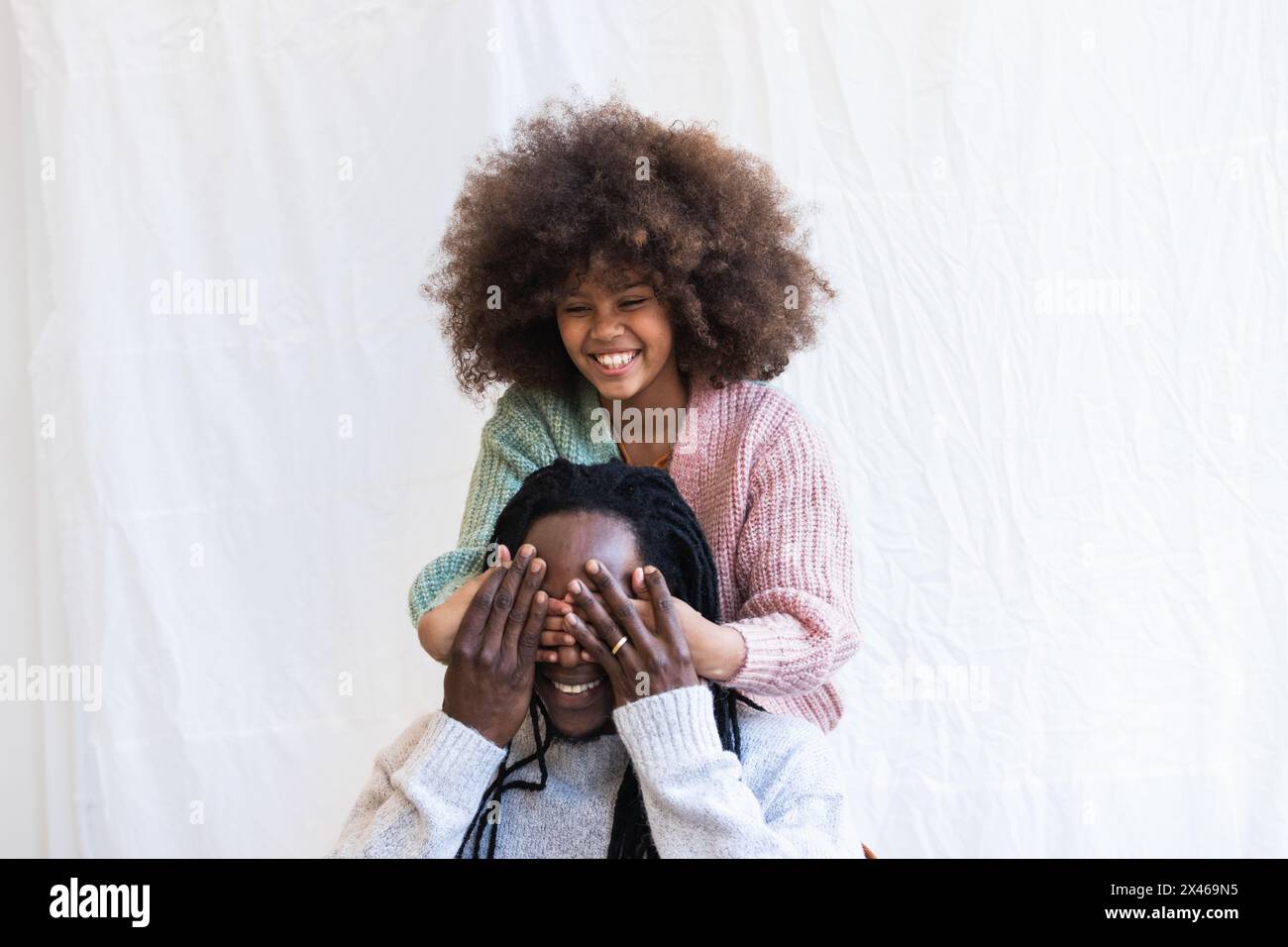 Positive African American daughter hiding behind back and covering eyes ...