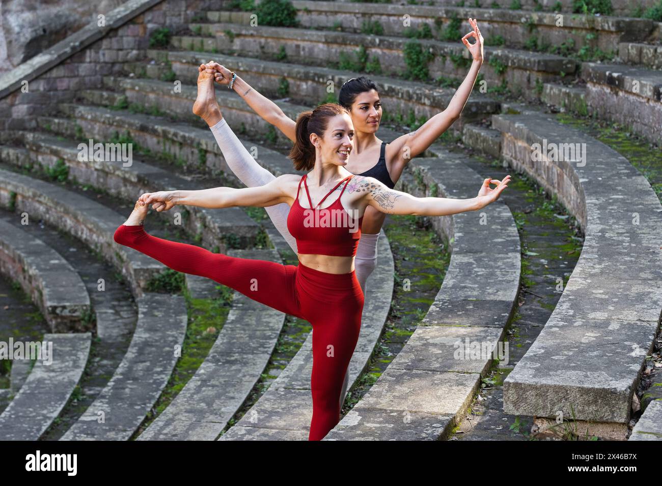 Flexible females in sportswear practicing yoga in Utthita Hasta ...