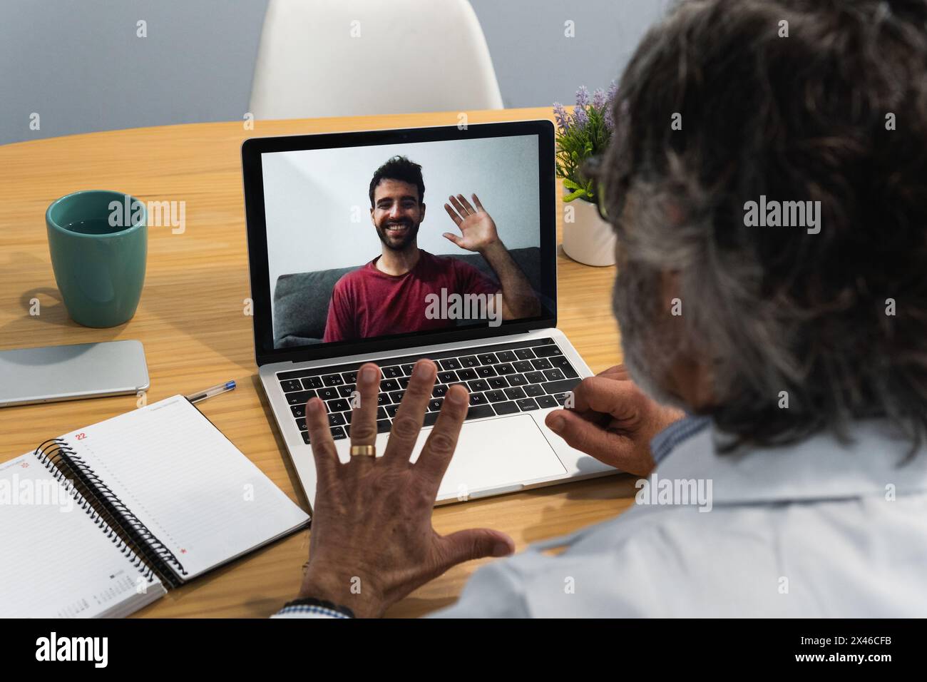 High angle of unrecognizable senior male doctor waving hand to patient ...