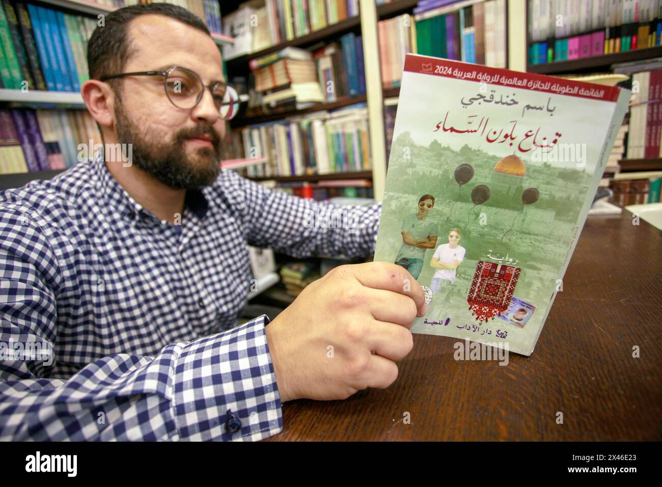 A man reads the book, "A Mask in the Color of the Sky" which won the ...