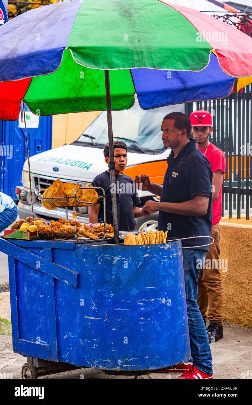Food vendors sell empanadas from a cart on the street at Carnival in La ...