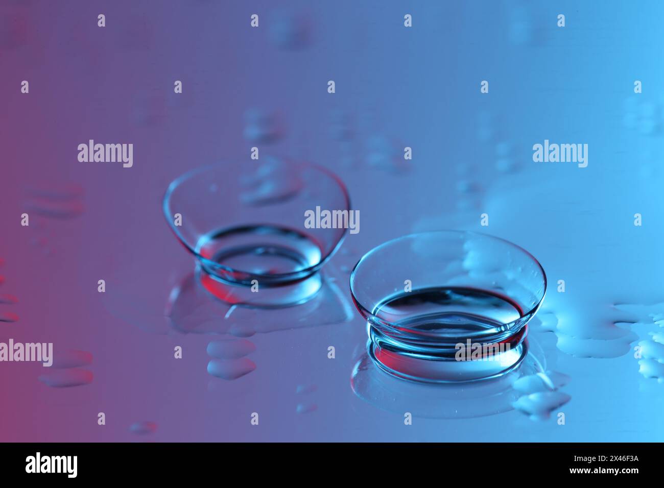 Pair of contact lenses on wet mirror surface Stock Photo - Alamy