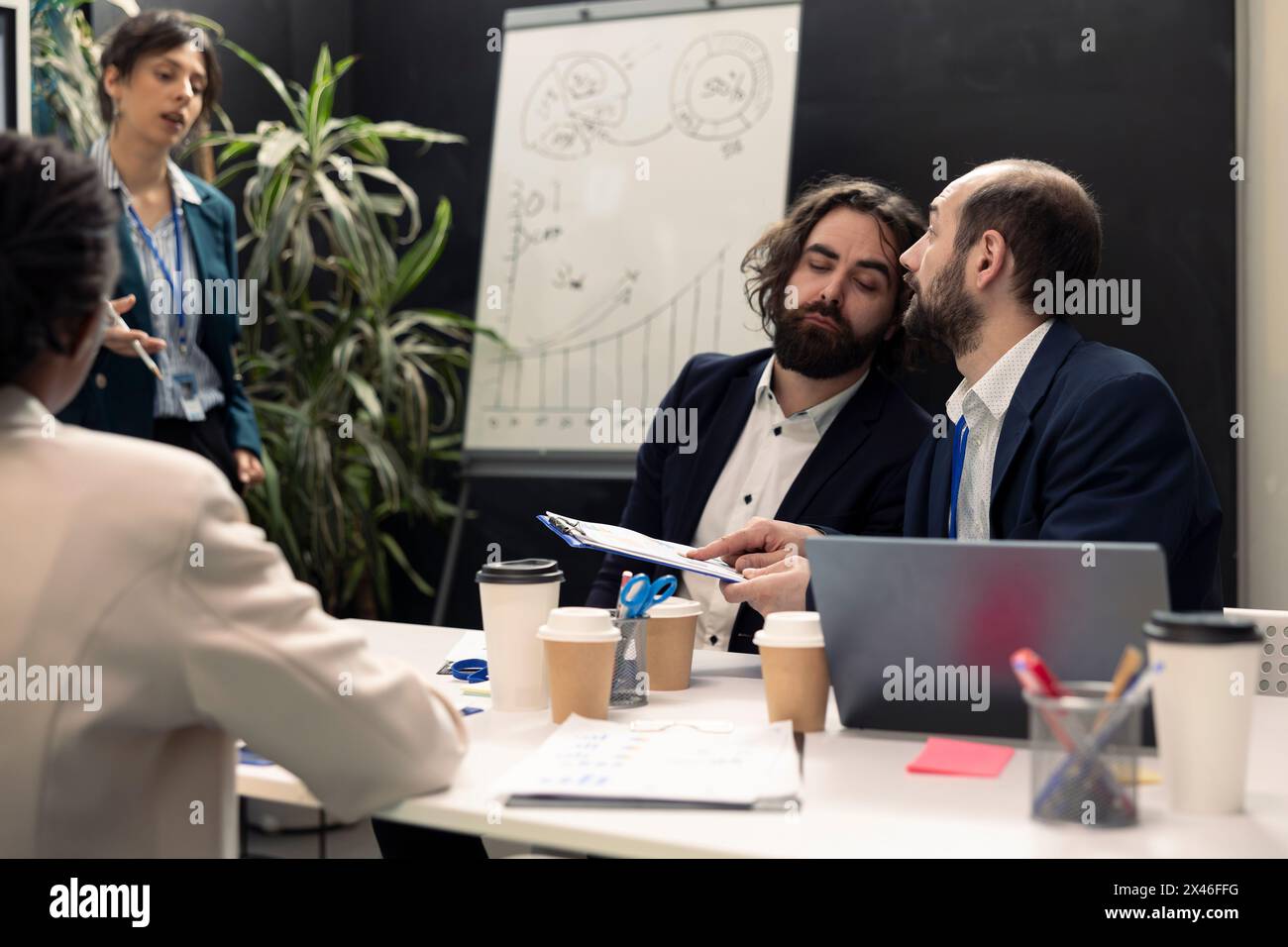 Enterprise colleagues discussing project updates and details in meeting ...