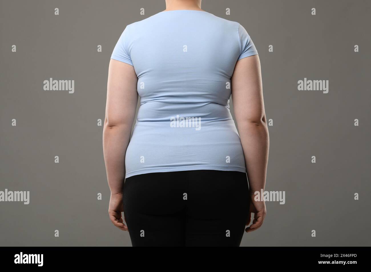 Overweight woman on grey background, back view Stock Photo - Alamy