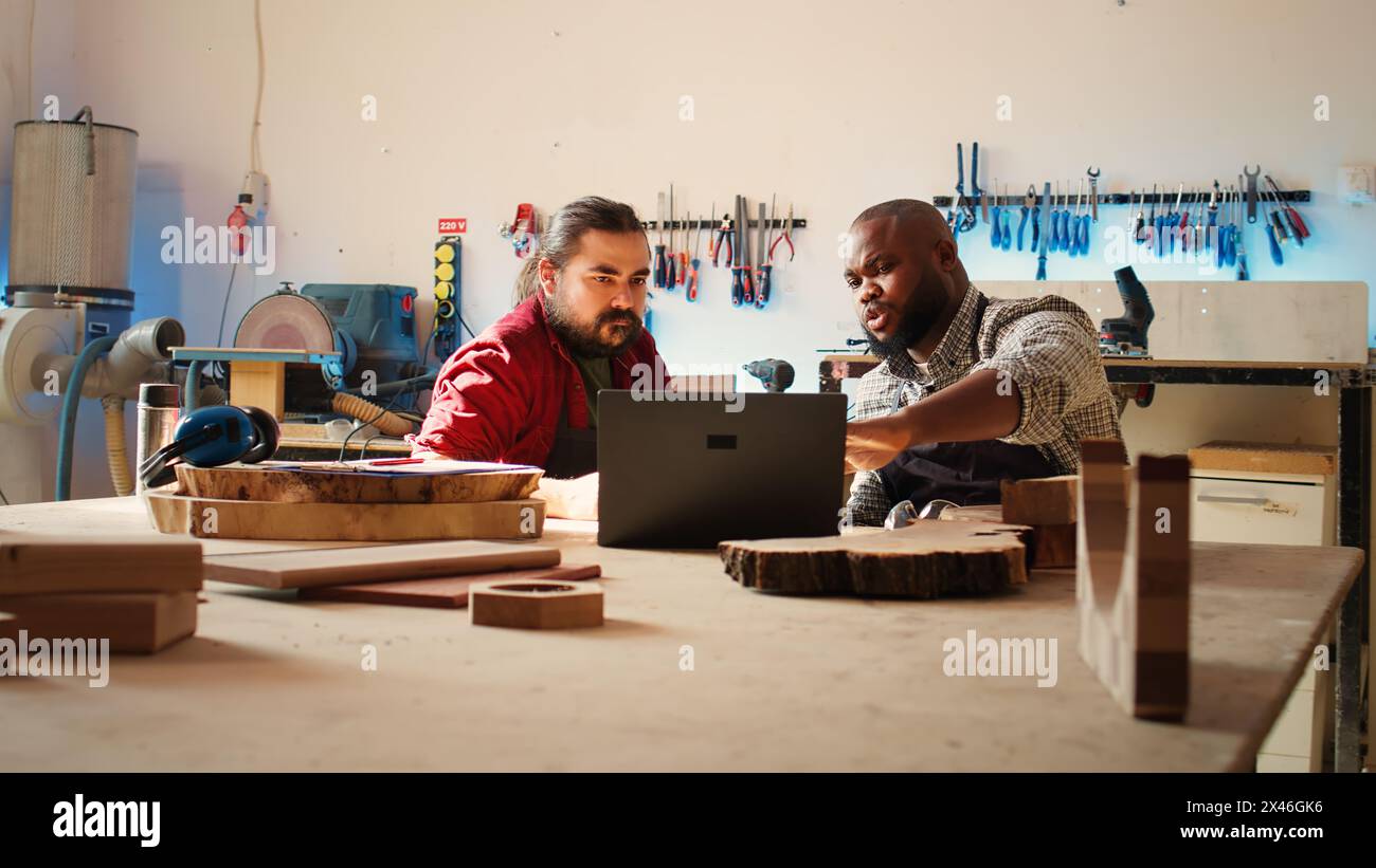 Woodworkers using CAD software on laptop to design wooden objects ...