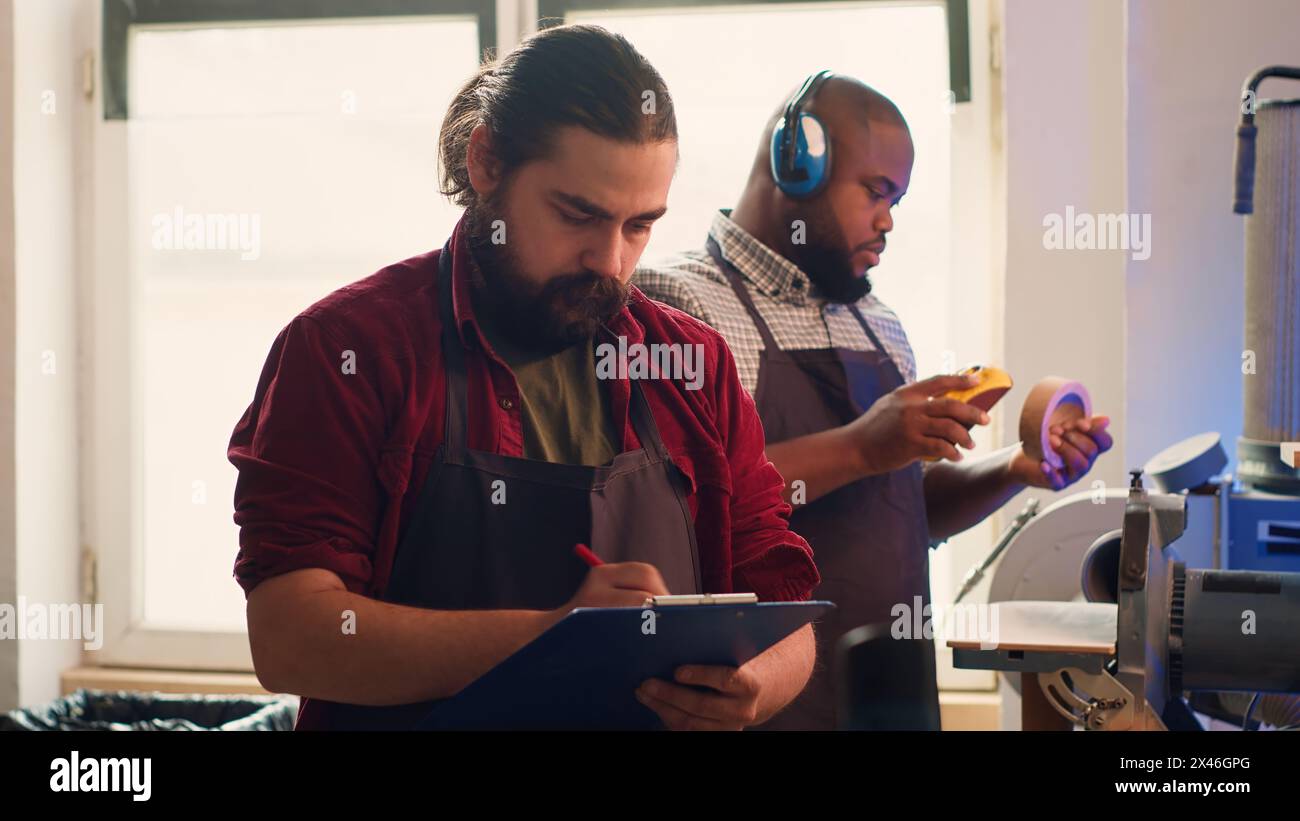 Craftsperson drawing blueprints on notepad in studio with BIPOC ...