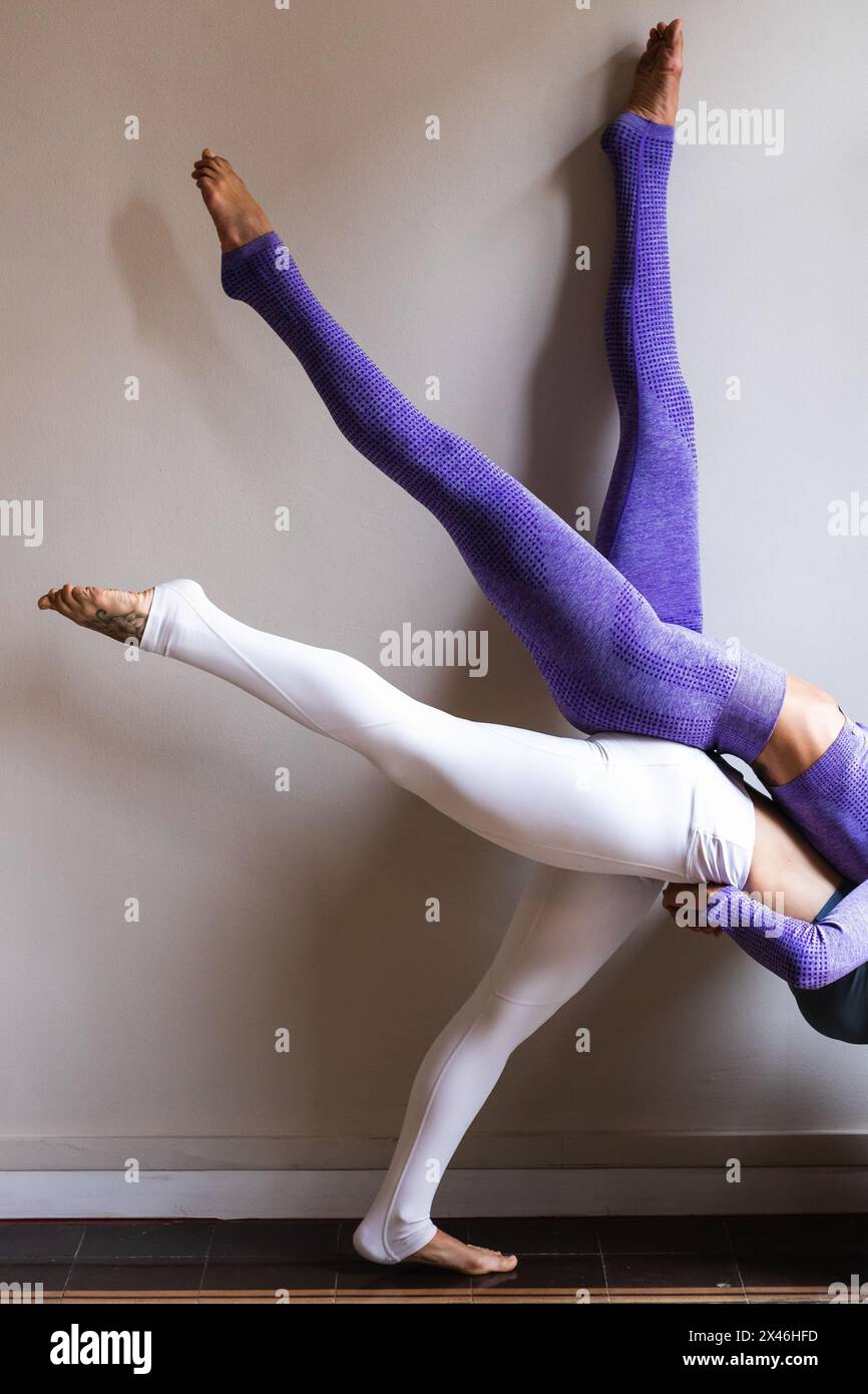 Side view of cropped unrecognizable fit woman lying on back of female ...