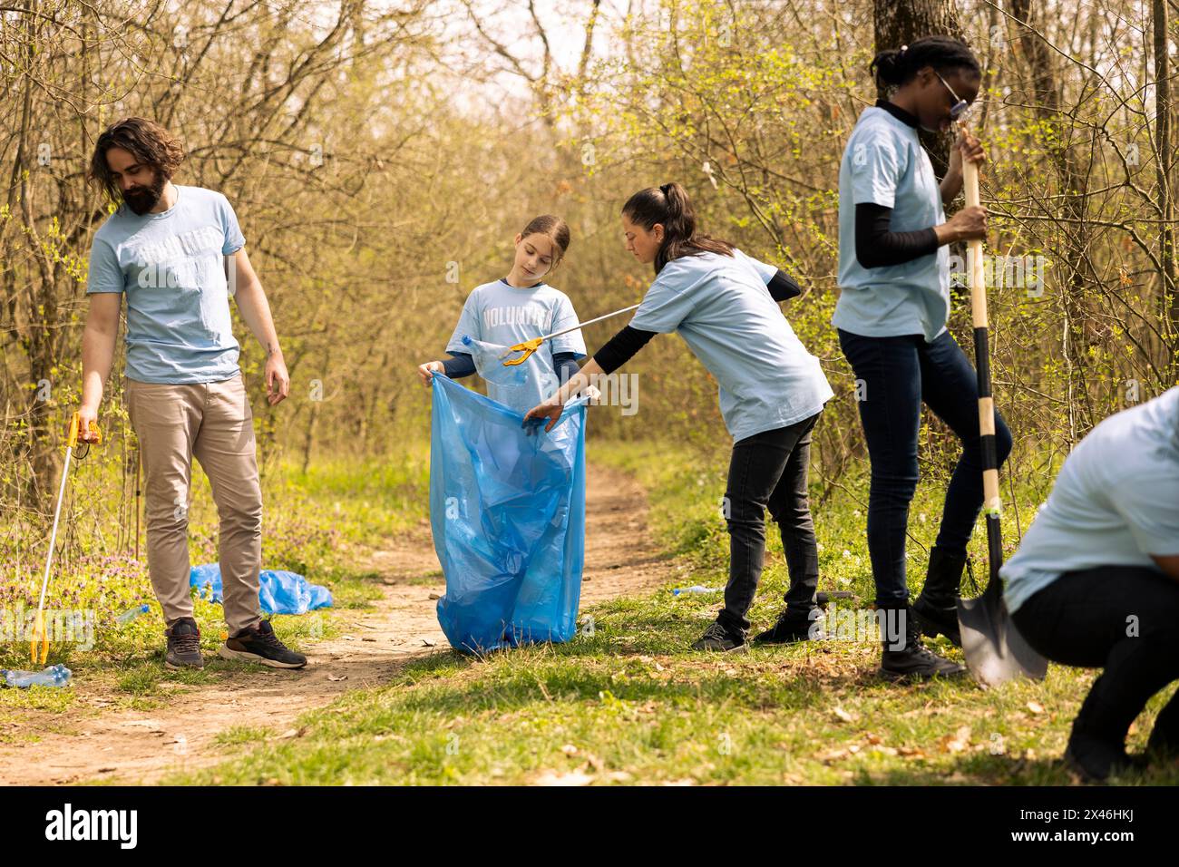 Group of diverse activists collecting trash from the forest and ...