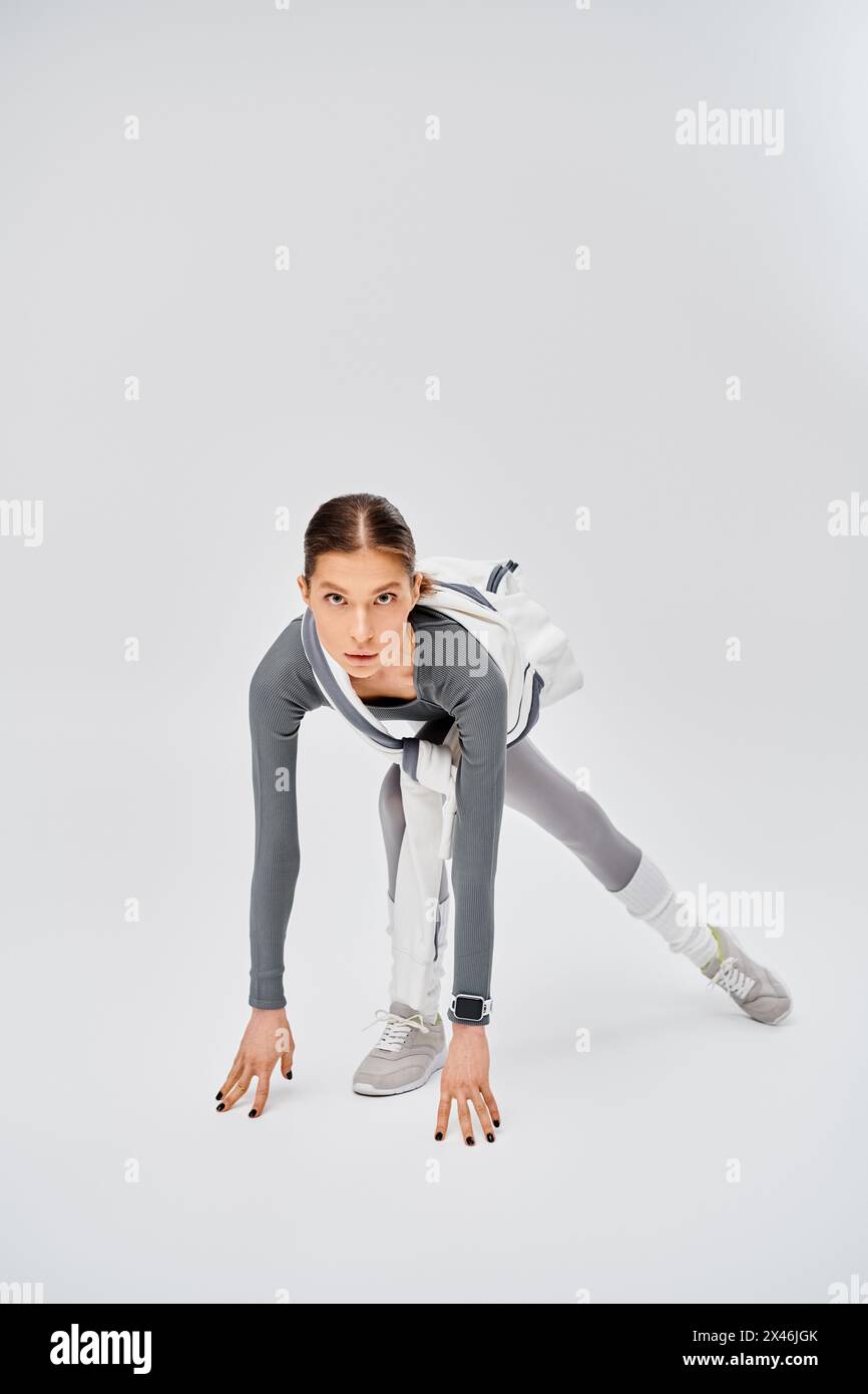 A sporty young woman in active wear showcases her strength and balance ...