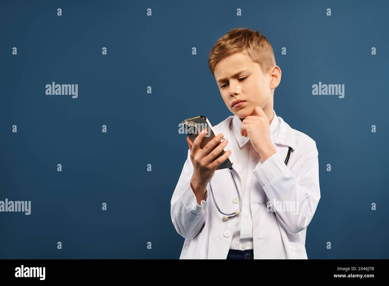 Boy in white lab coat captivated by smartphone screen Stock Photo - Alamy