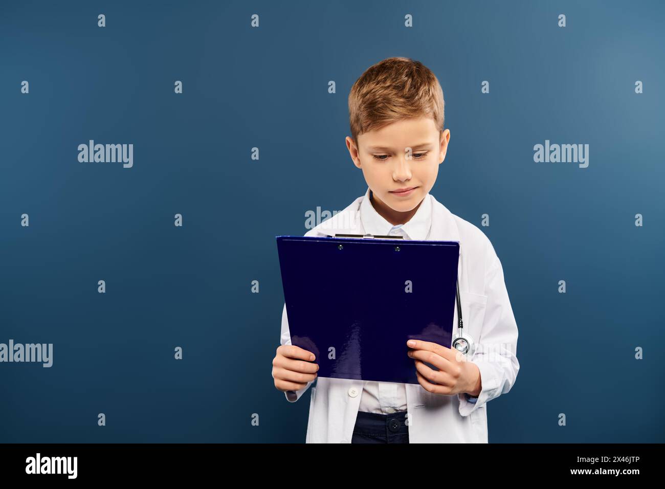 A young boy in doctor attire holding a blue folder Stock Photo - Alamy
