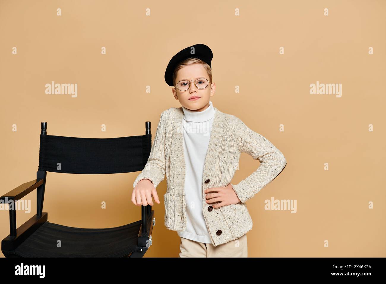 A cute preadolescent boy dressed as a film director standing next to a ...