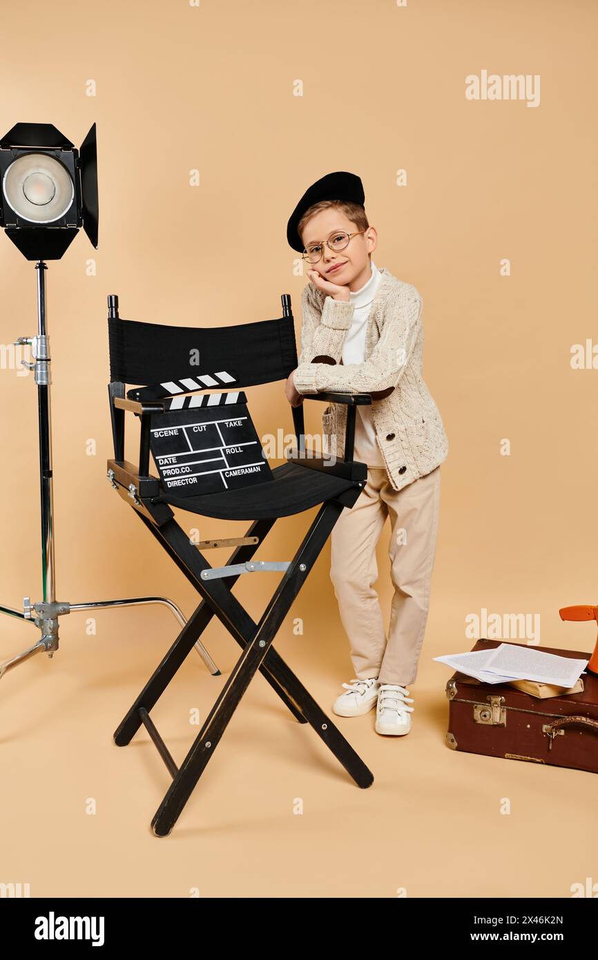 A preadolescent boy dressed as a film director stands confidently ...