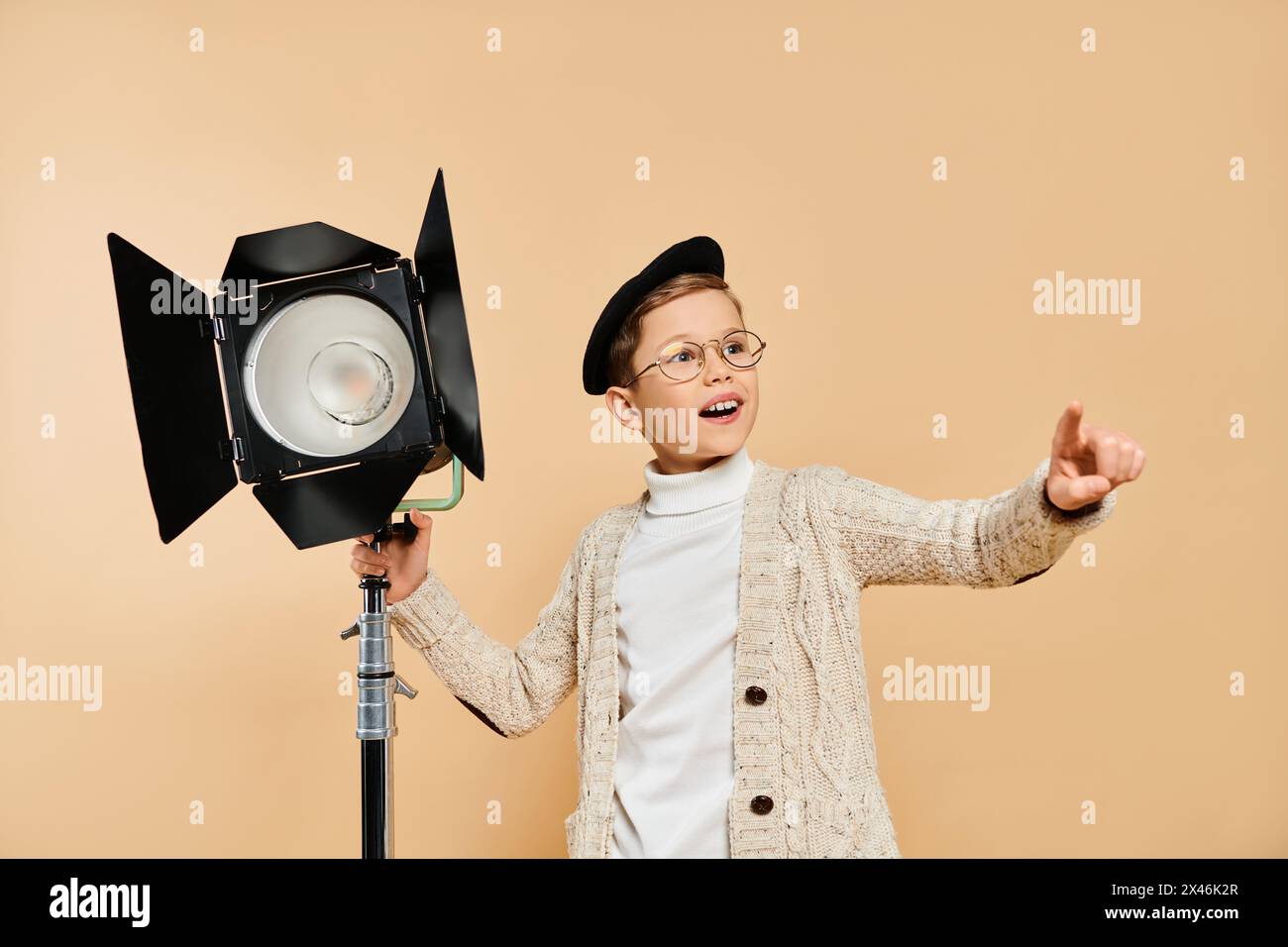 A cute preadolescent boy dressed as a film director, holding a camera ...