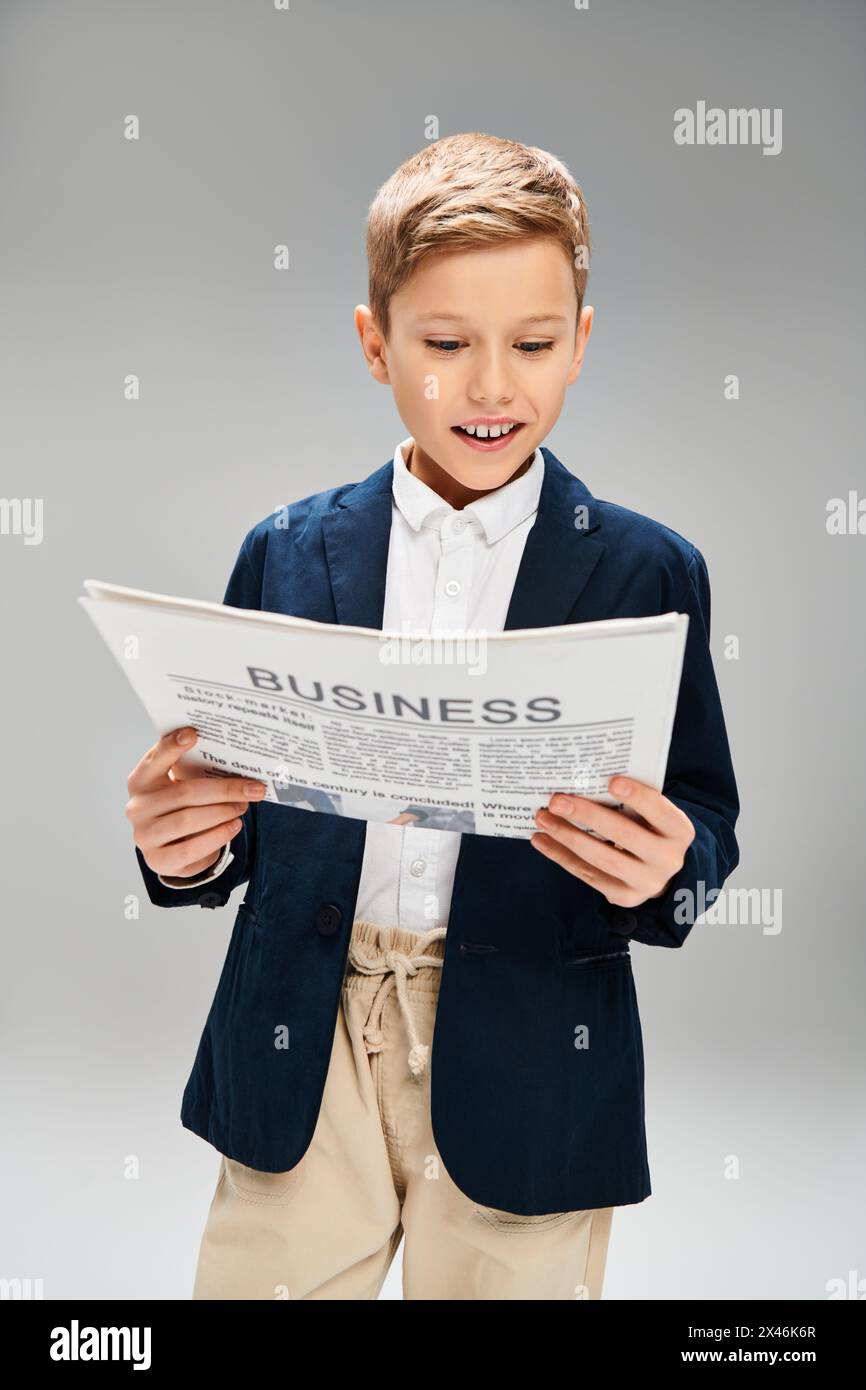 A stylish young boy in a suit deeply engrossed in reading a newspaper ...