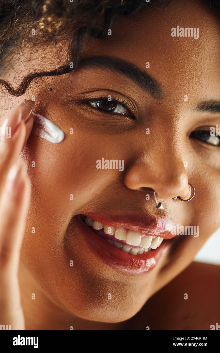 African American woman applying cream to her face Stock Photo - Alamy