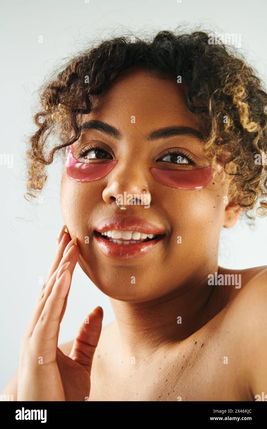 African American woman with pink eye patches posing creatively Stock ...