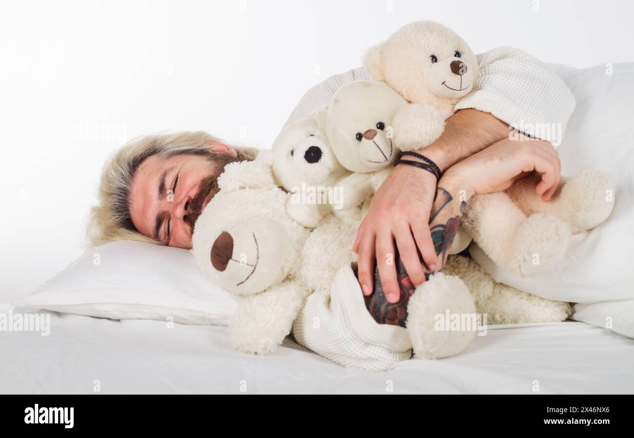 Good night. Handsome bearded male sleeping with teddy bears on in bed ...