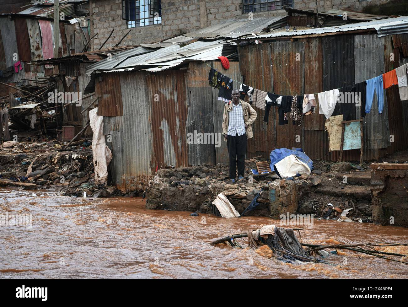 Nairobi, Kenya. 30th Apr, 2024. A man stands by a flooded river in the ...