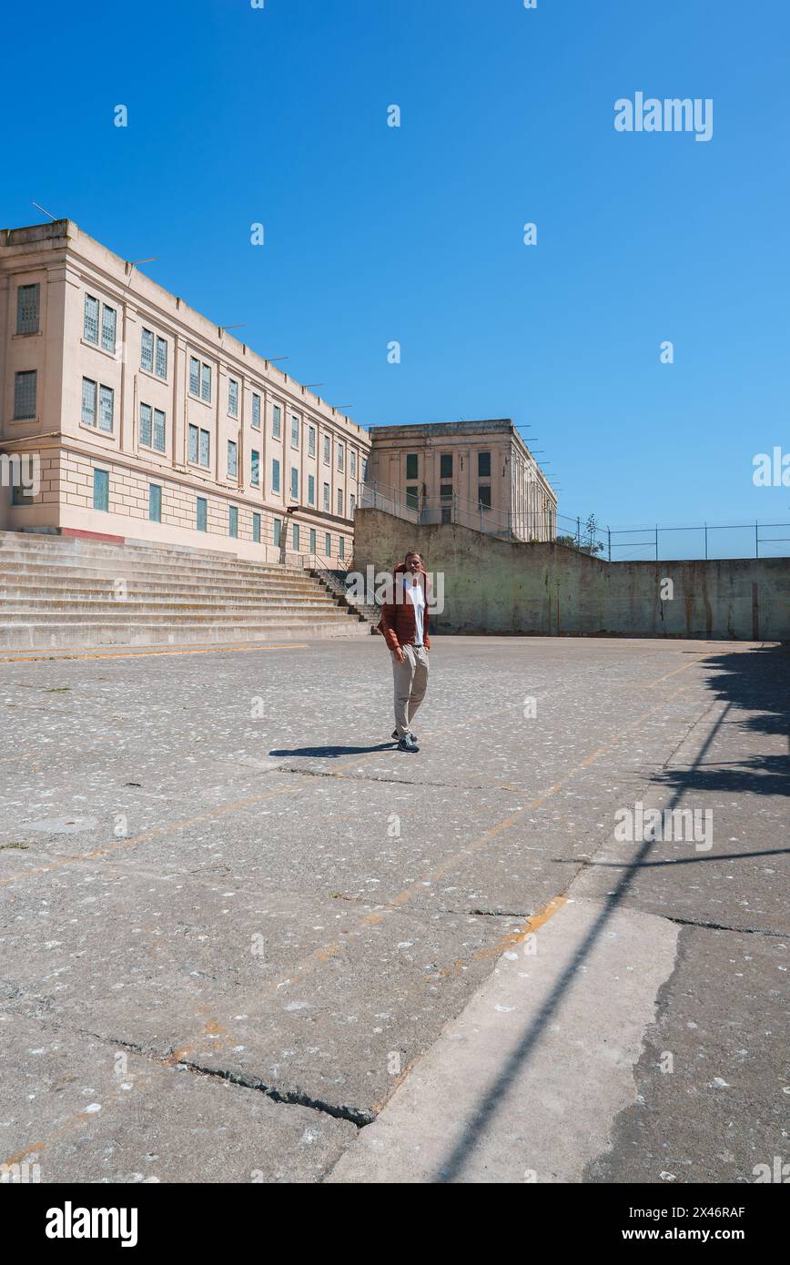 Alcatraz prison visitor in yard with looming building, San Francisco ...
