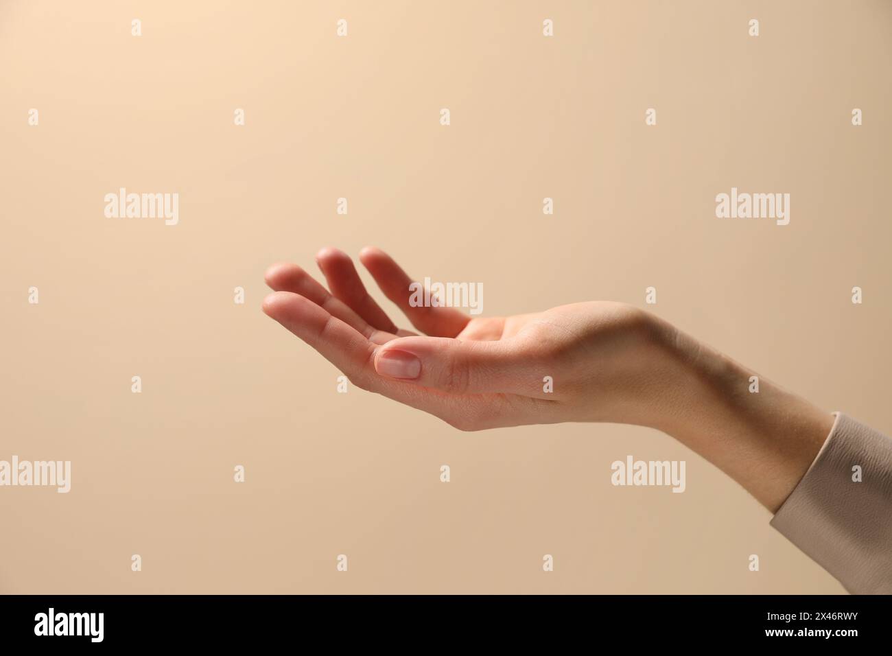 Woman holding something in hand on beige background, closeup Stock ...